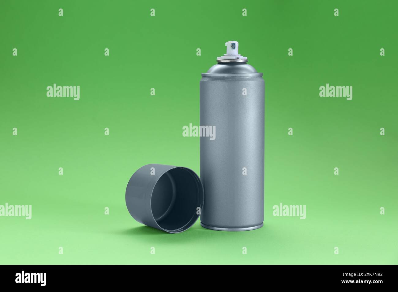 Gray spray paint can on green background Stock Photo - Alamy