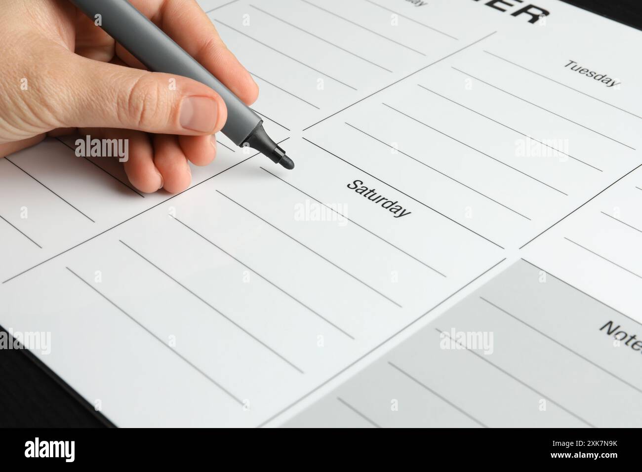 Timetable. Man making schedule using weekly planner at table, closeup ...