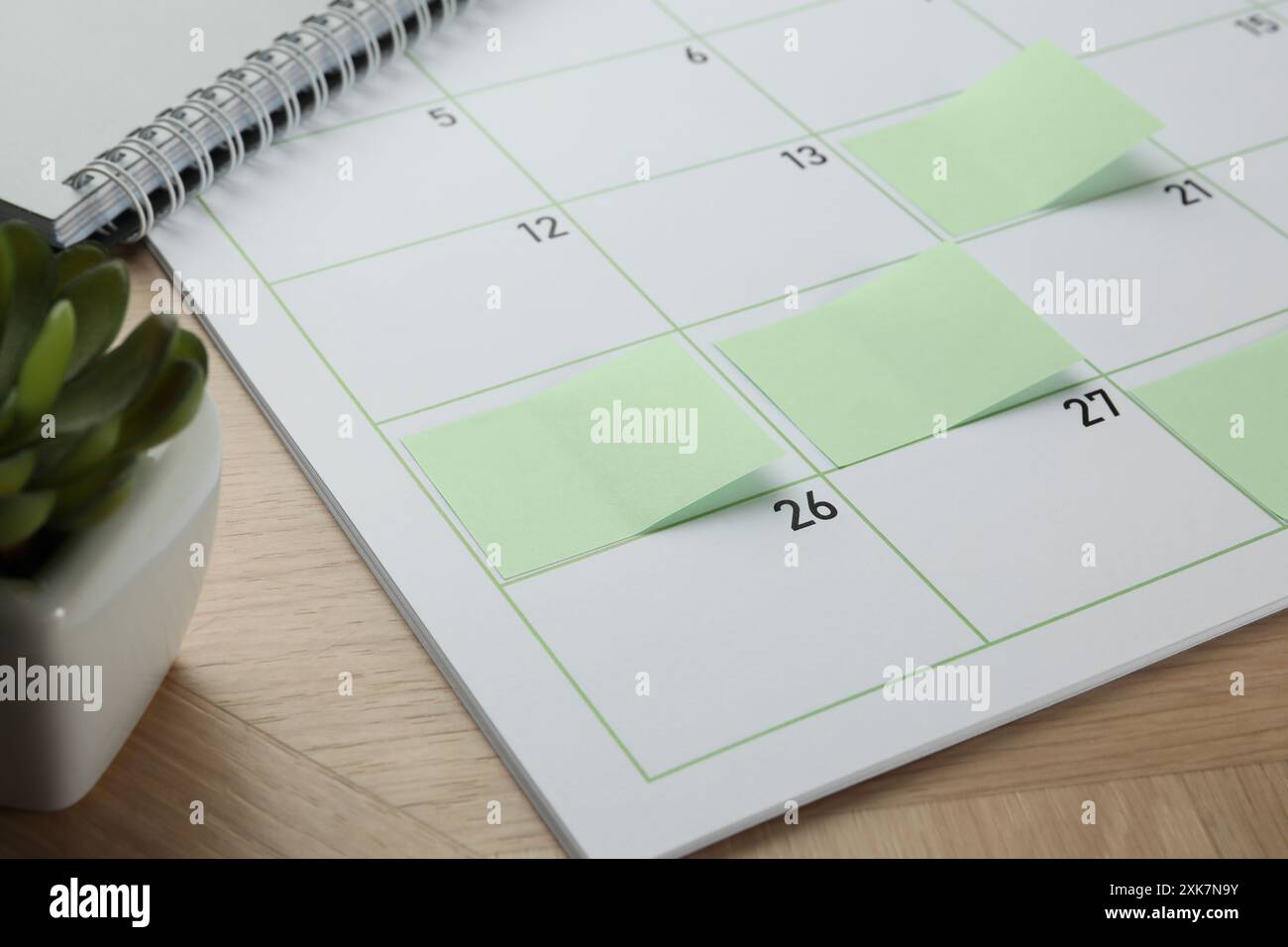 Timetable. Calendar page with green sticky notes on wooden table ...
