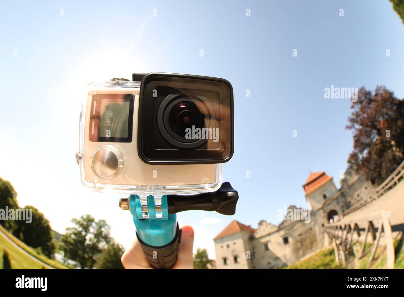 Man with modern action camera and monopod outdoors, closeup. Fisheye ...