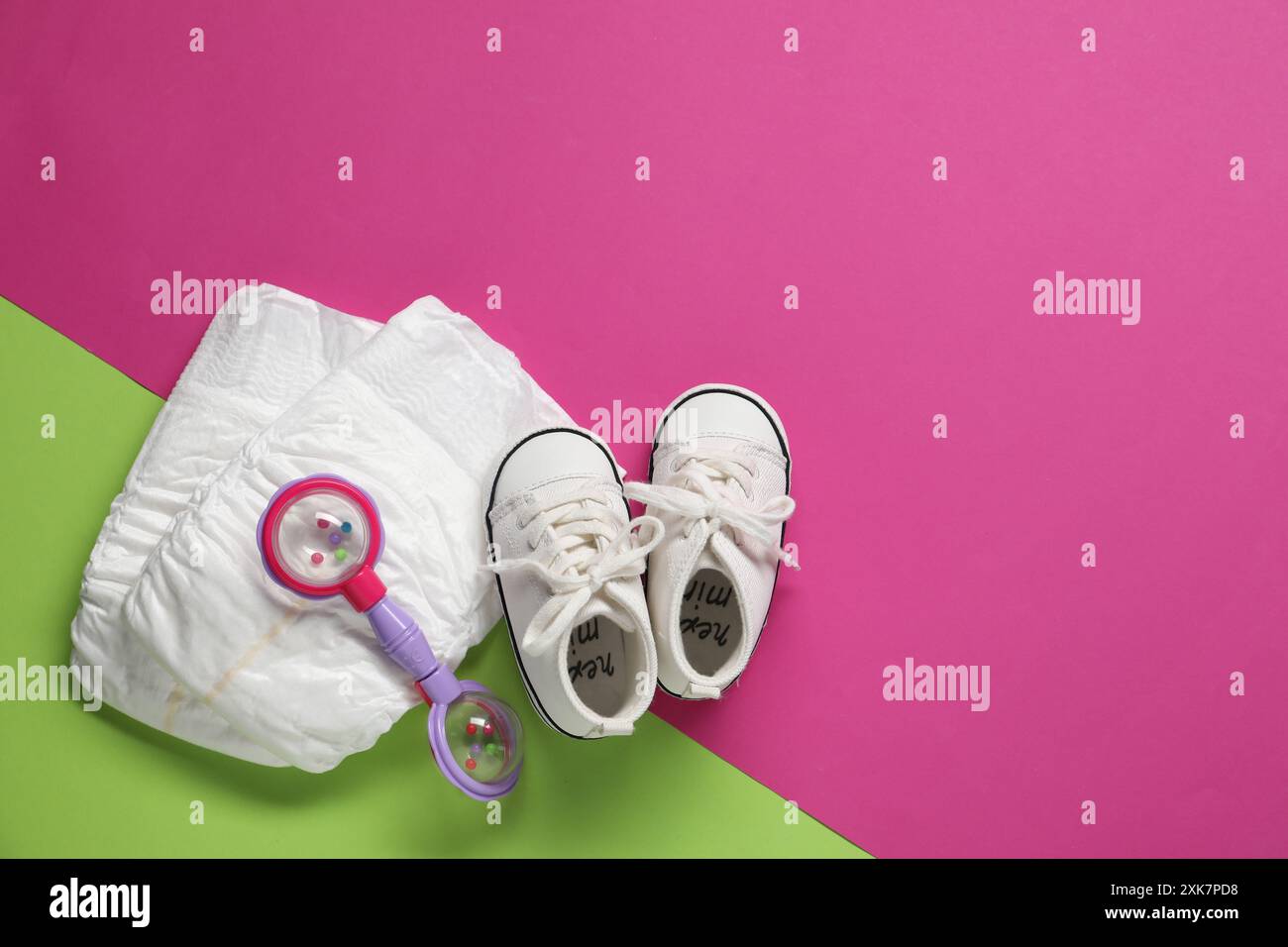 Baby rattle, booties and diapers on color background, top view. Space ...