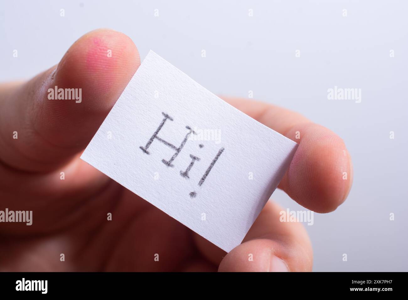 Hand holding notepaper with HI wording on white background Stock Photo ...