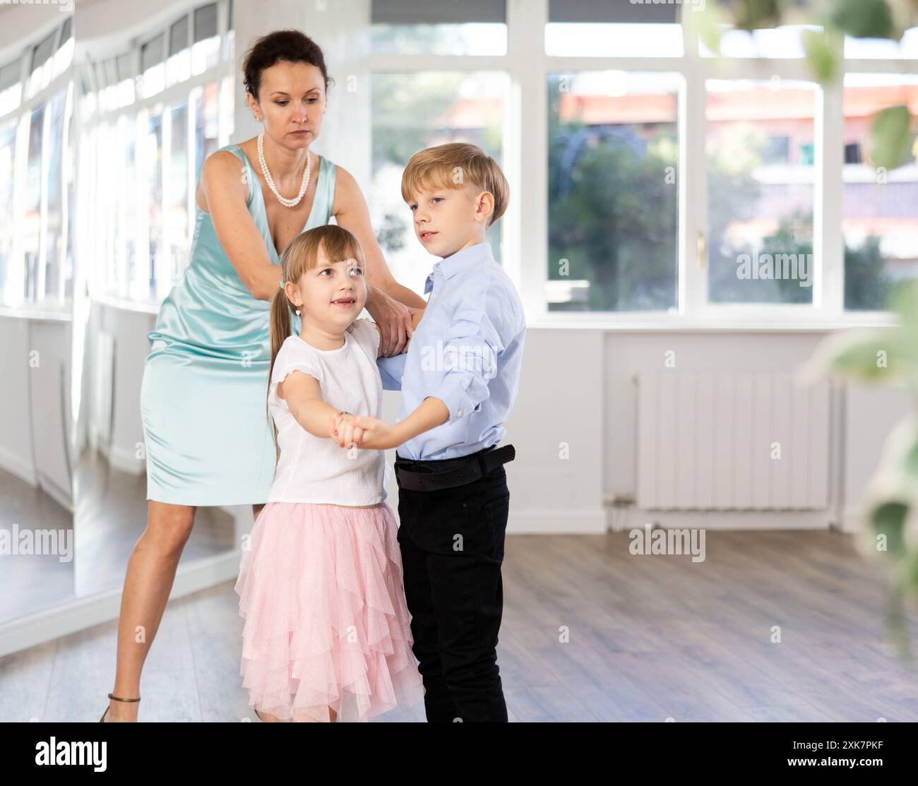Teacher rearrange dancers pose during pair ballroom dancing lesson ...
