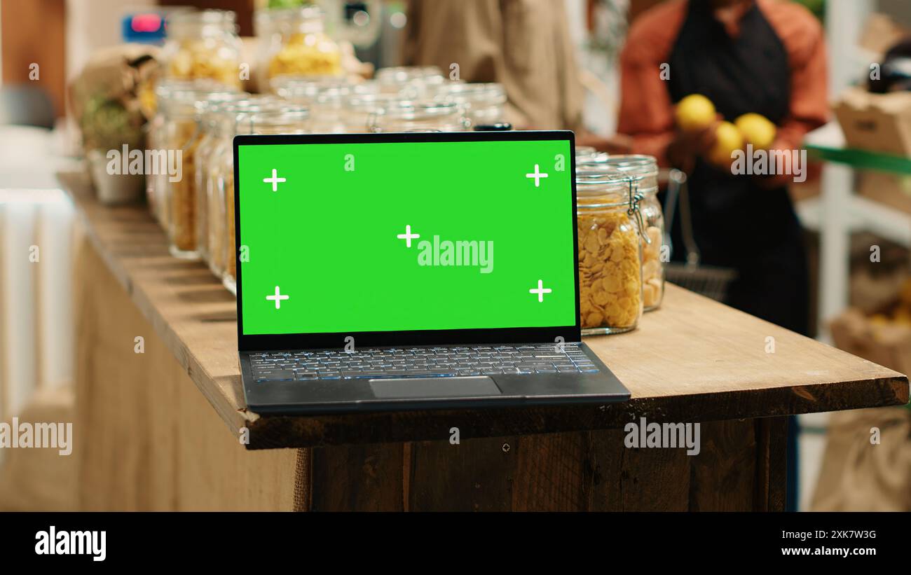 Computer showing blank chromakey display next to goods in jars, local ...