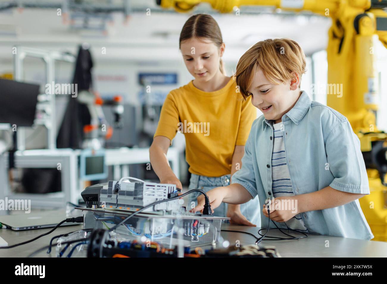 Two classmates working together on circuit board, building robot in ...