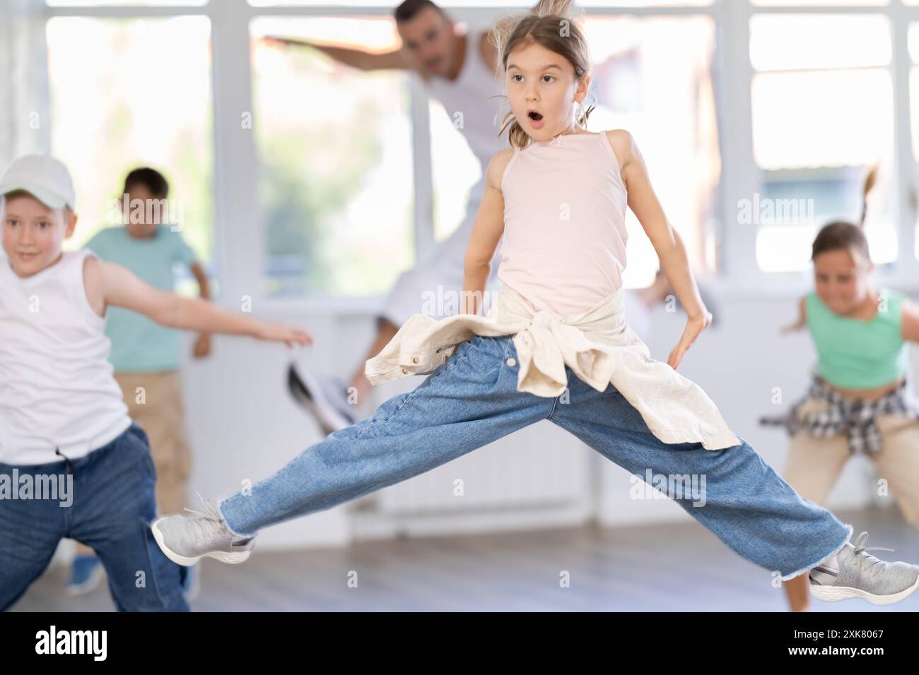 Preteen girl in mid-jump during hip hop dance class Stock Photo - Alamy