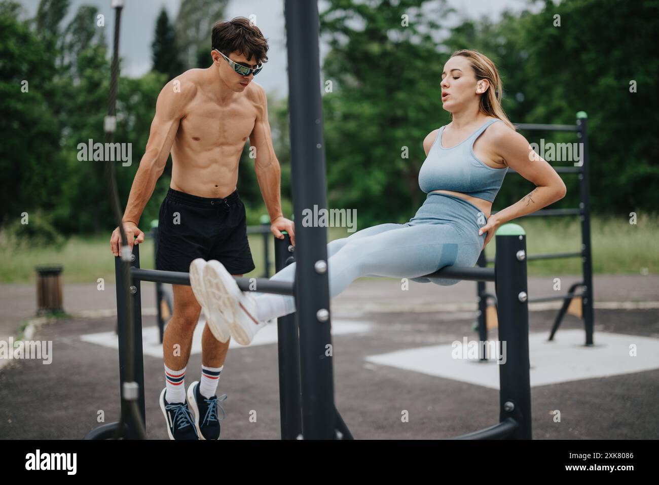 Outdoor calisthenics workout with fit man and woman at park fitness ...