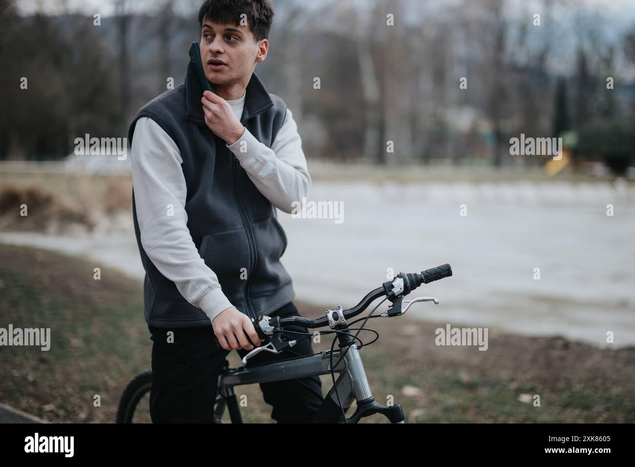 Teenage boy takes a break during a bike ride in the park Stock Photo ...