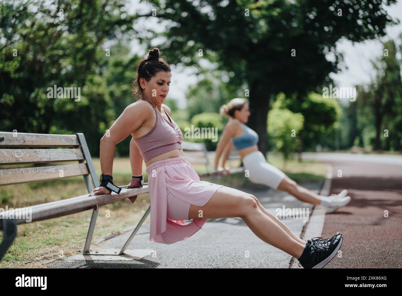 Women exercising outdoor on park bench, triceps dips workout for ...