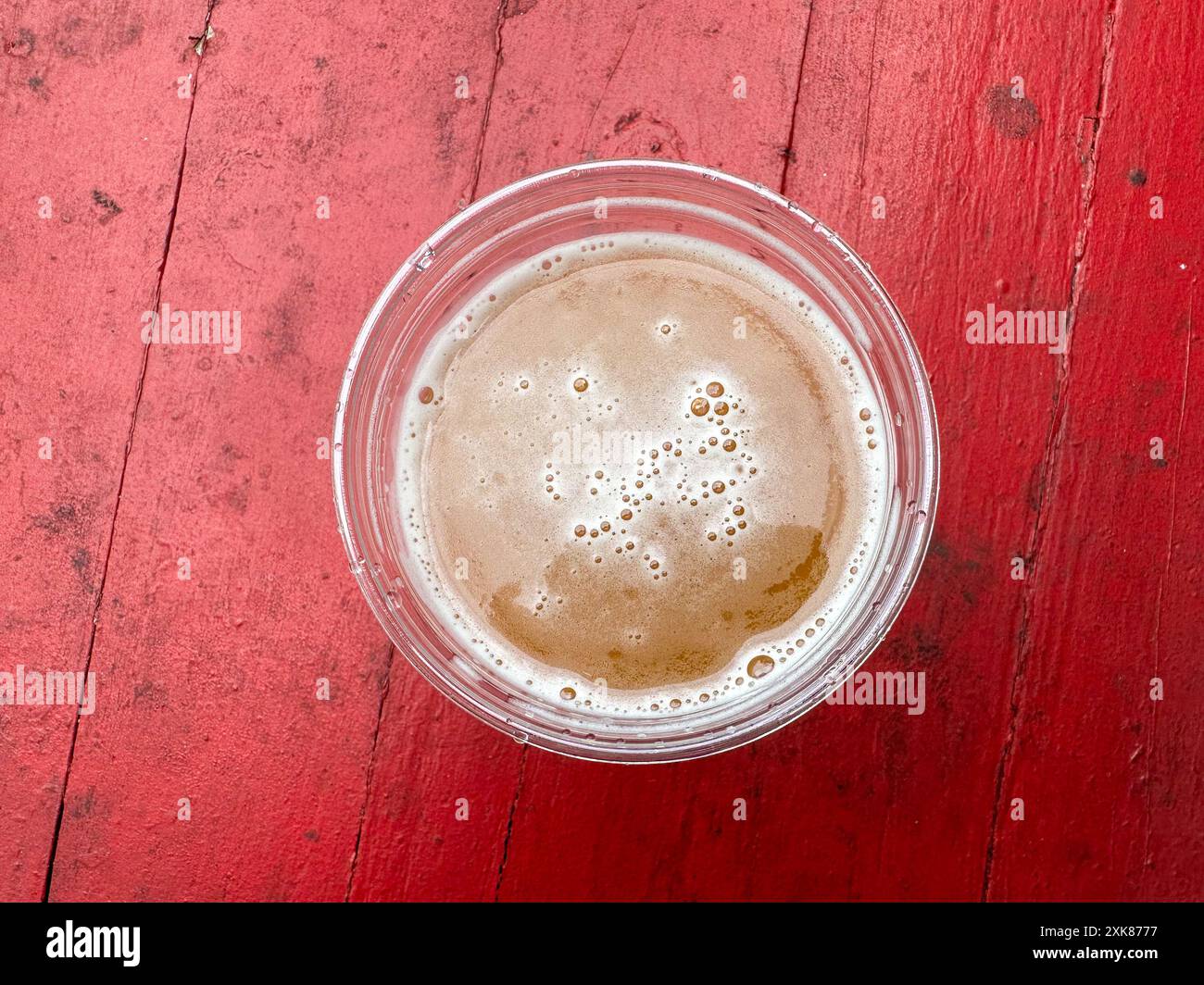 A top-down view of a clear glass of Belgian beer. The creamy carbonated ...