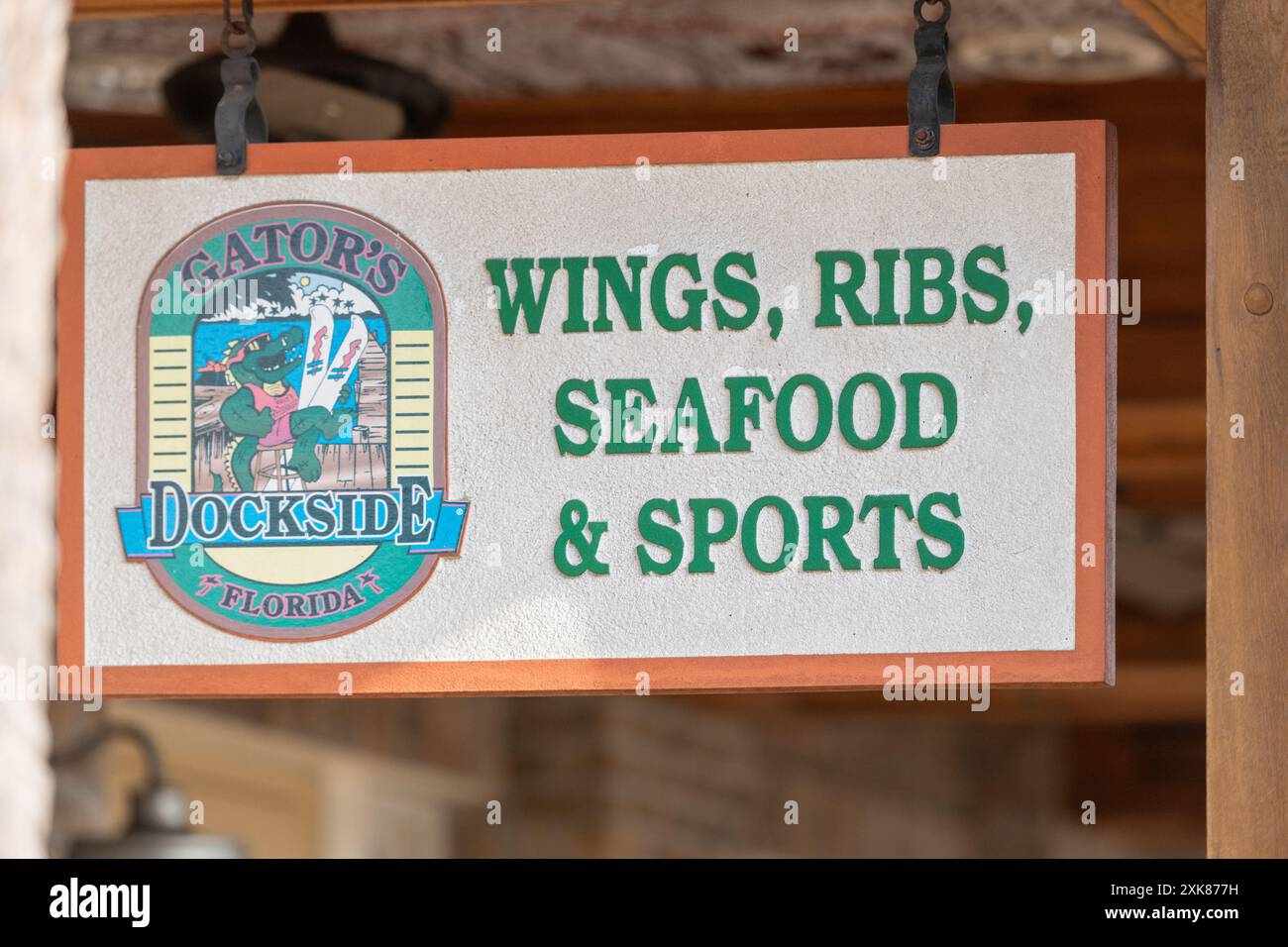 Gator's Dockside Sports Bar sign hanging from a wooden beam. The banner ...