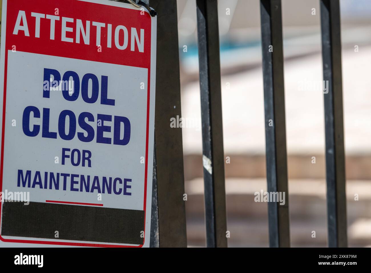 Attention pool closed for maintenance sign posted on a black metal ...