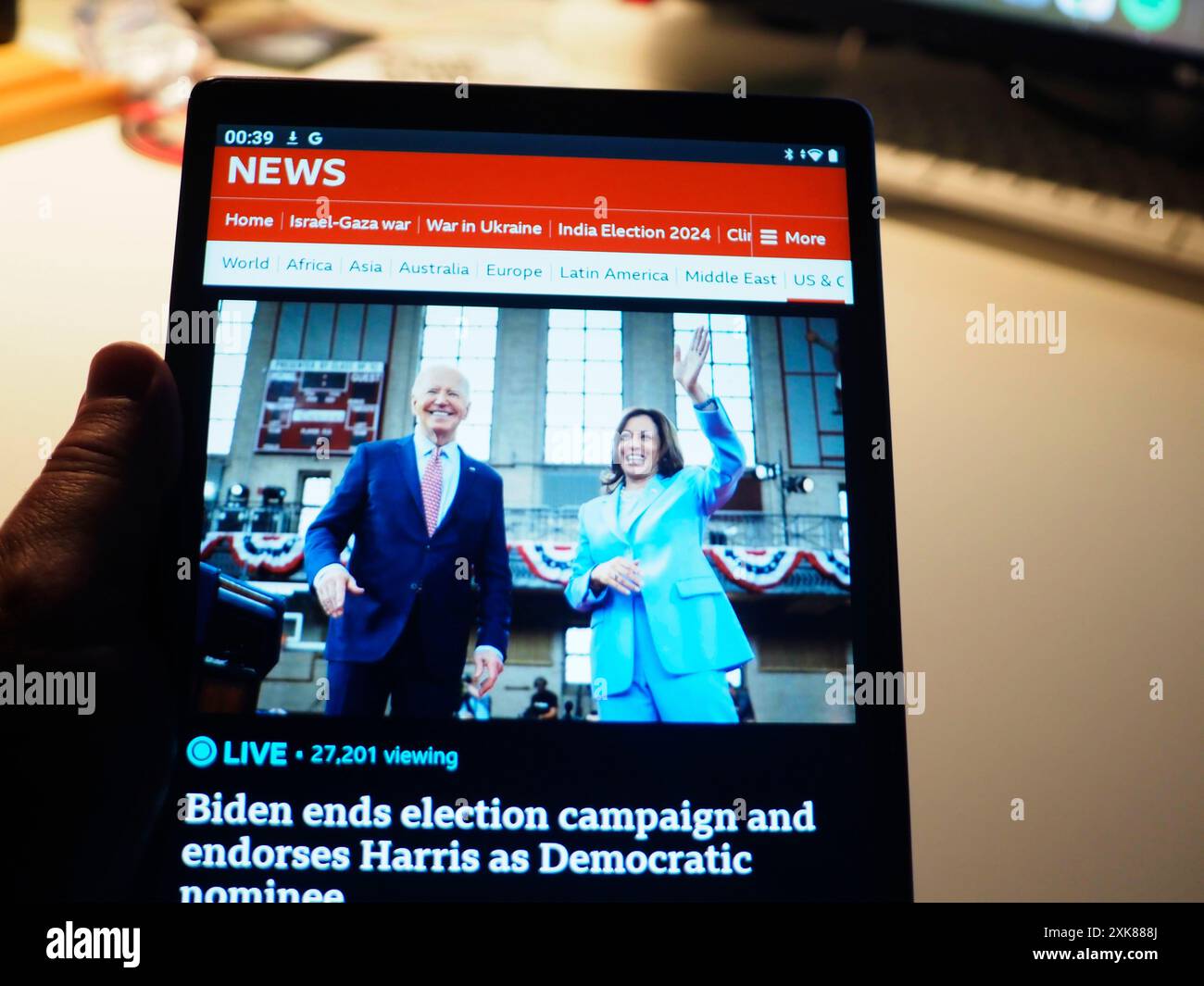 In this photo illustration, a hand holds a tablet showing a BBC message ...