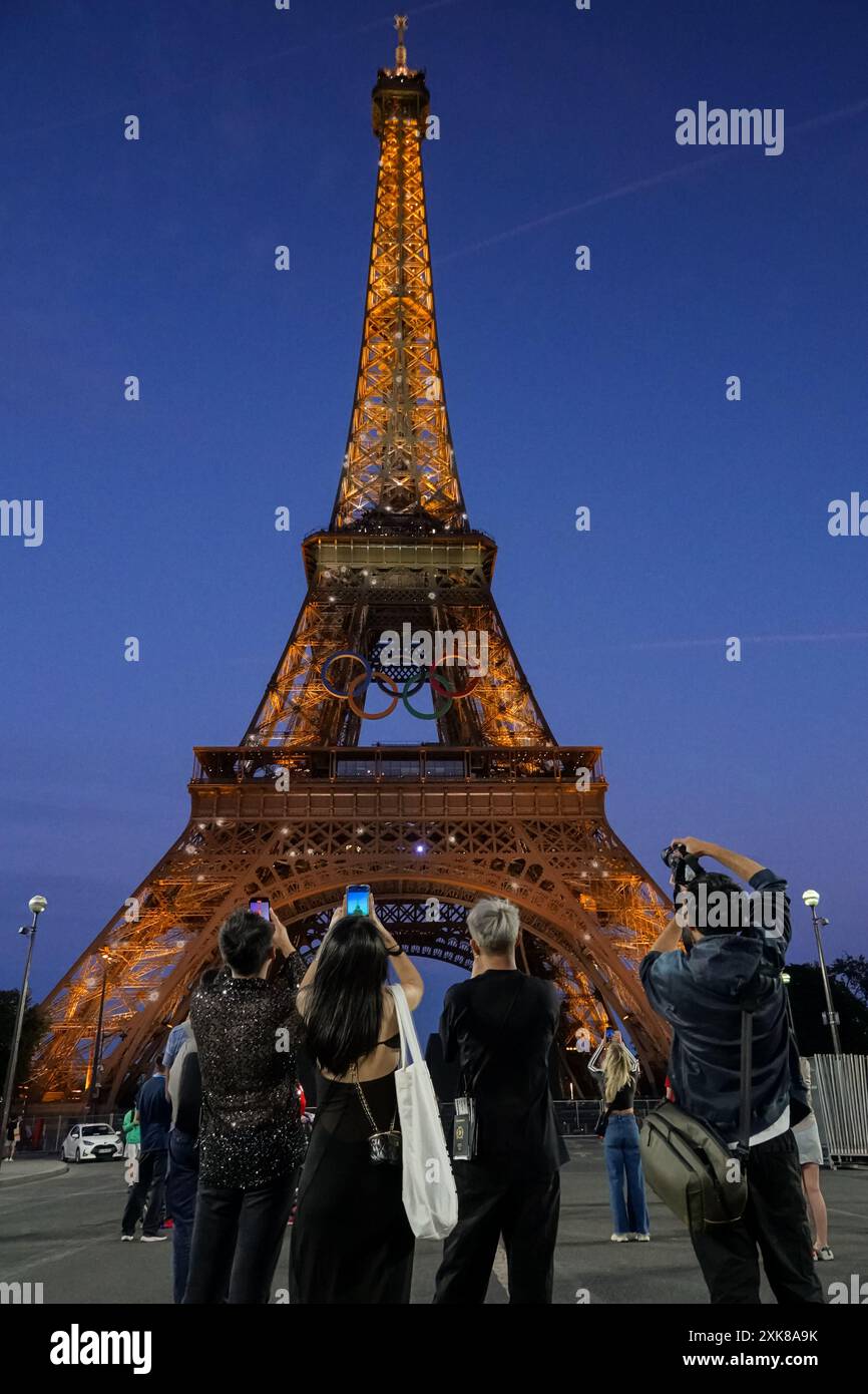 Paris, France. 21st July, 2024. People stop to take photos of the lighted Eiffel Tower during ...