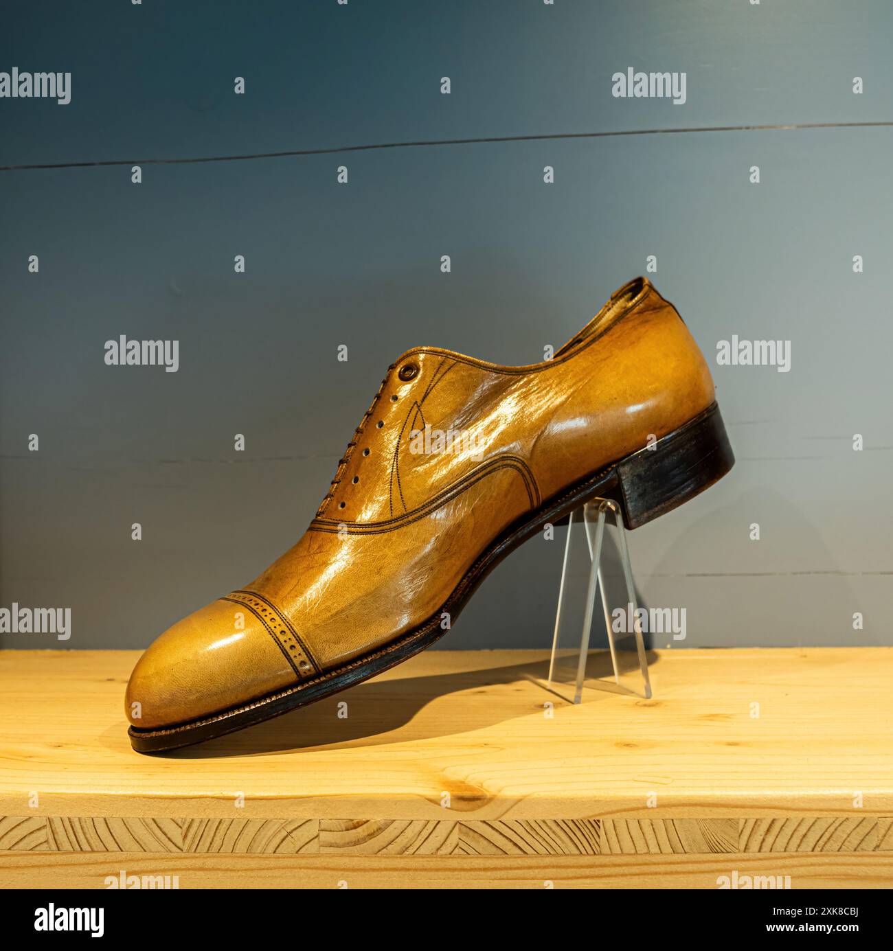 A vintage tan leather oxford shoe with perforated cap-toe detailing is ...