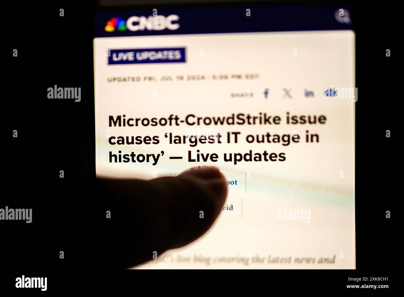Paris, France - Jul 20, 2024: A close-up of an iPhone finger displaying a CNBC article headline ...