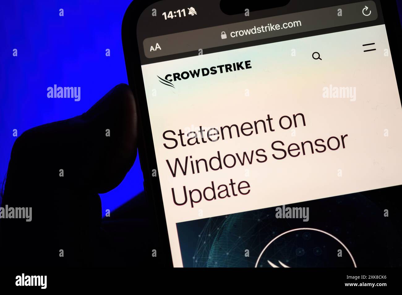 Paris, France - Jul 20, 2024: A male hand holds an iPhone displaying a CrowdStrike webpage with ...