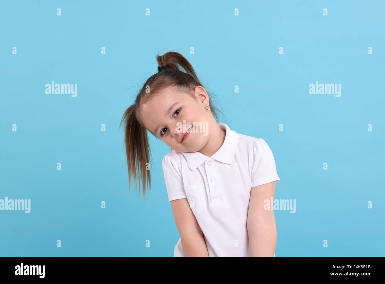 Portrait of cute little girl on light blue background Stock Photo - Alamy