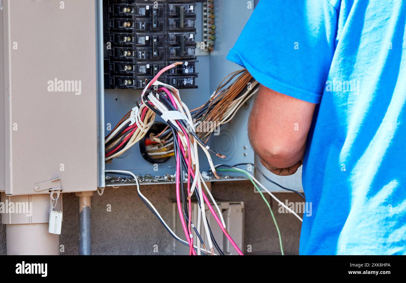Electrician installing a transfer panel for a whole house generator ...