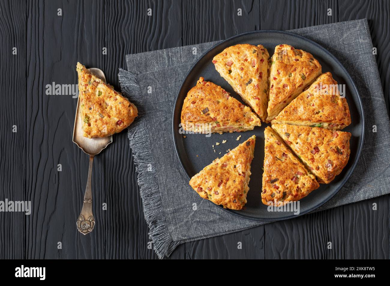 Ham and cheese triangle scones on platter with cake shovel on black ...