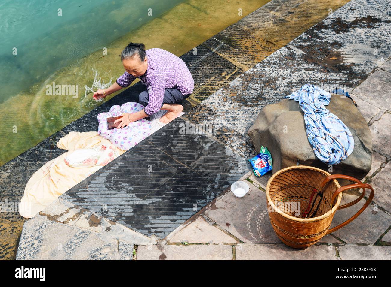 Top view of old Chinese woman washing clothes in river Stock Photo - Alamy