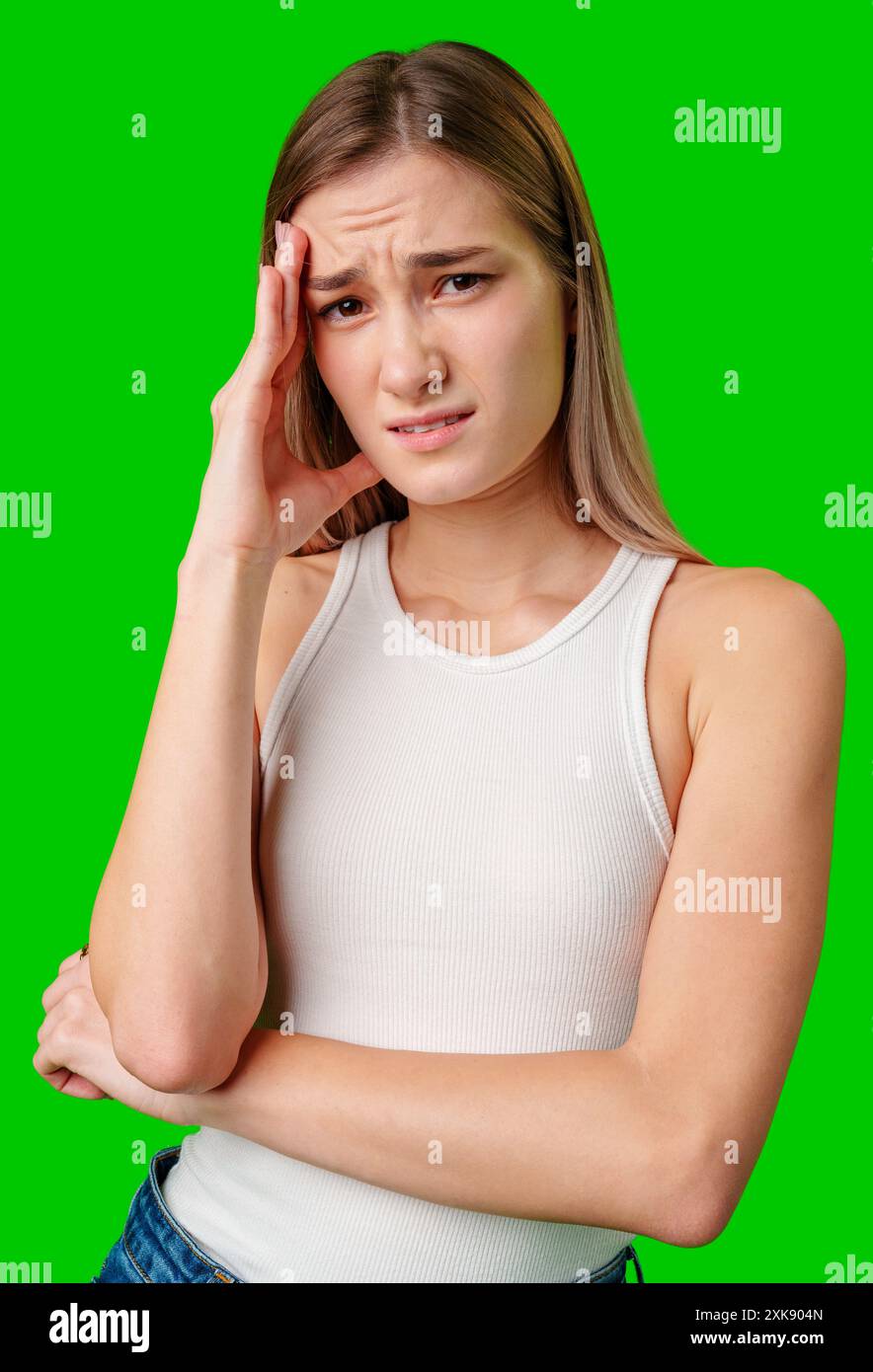 Young Woman With Worried Expression Holding Her Forehead Against Green ...