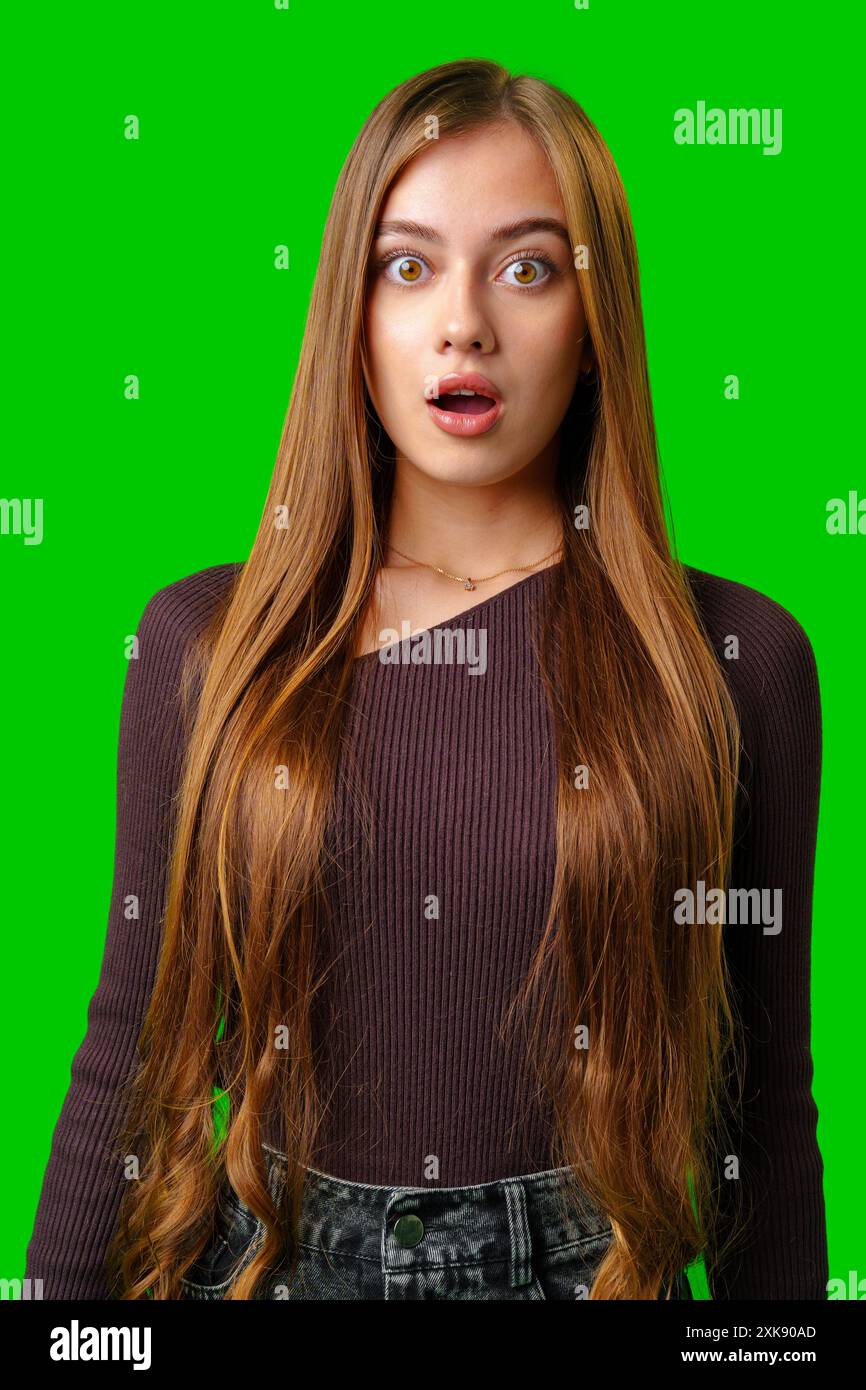 Young Woman With Long Brown Hair Looks Surprised in Front of Green ...