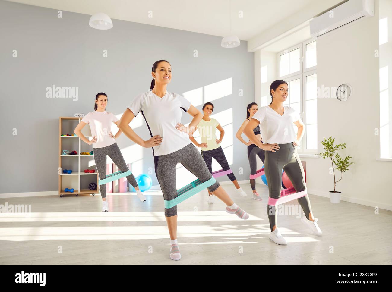Sporty girls doing fitness workout with rubber resistance band ...