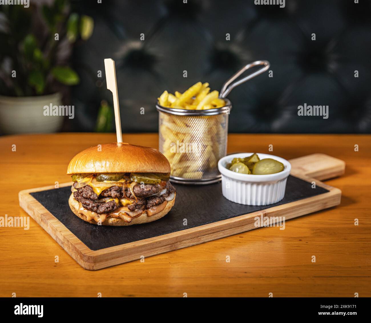 Delicious double beef burger standing on black slate with french fries ...