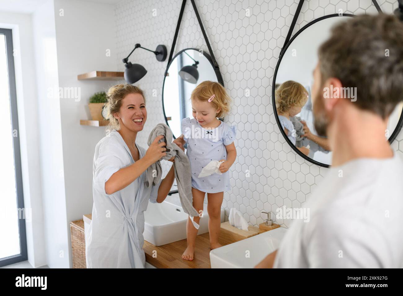 Parents and daughter having morning bathroom routine, brushing teeth ...