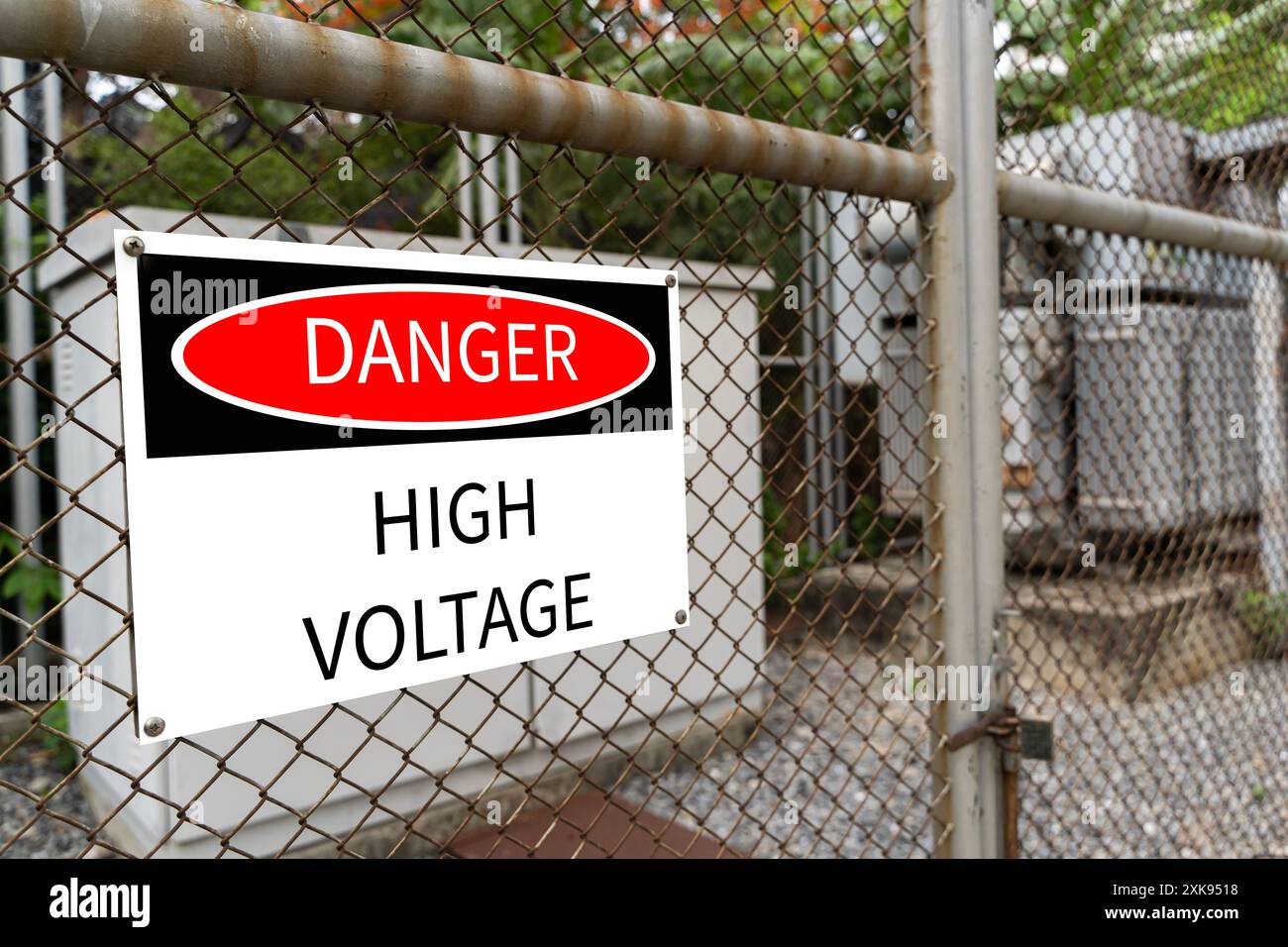 High-voltage transformer substation behind barbed-wire chain-link fence ...