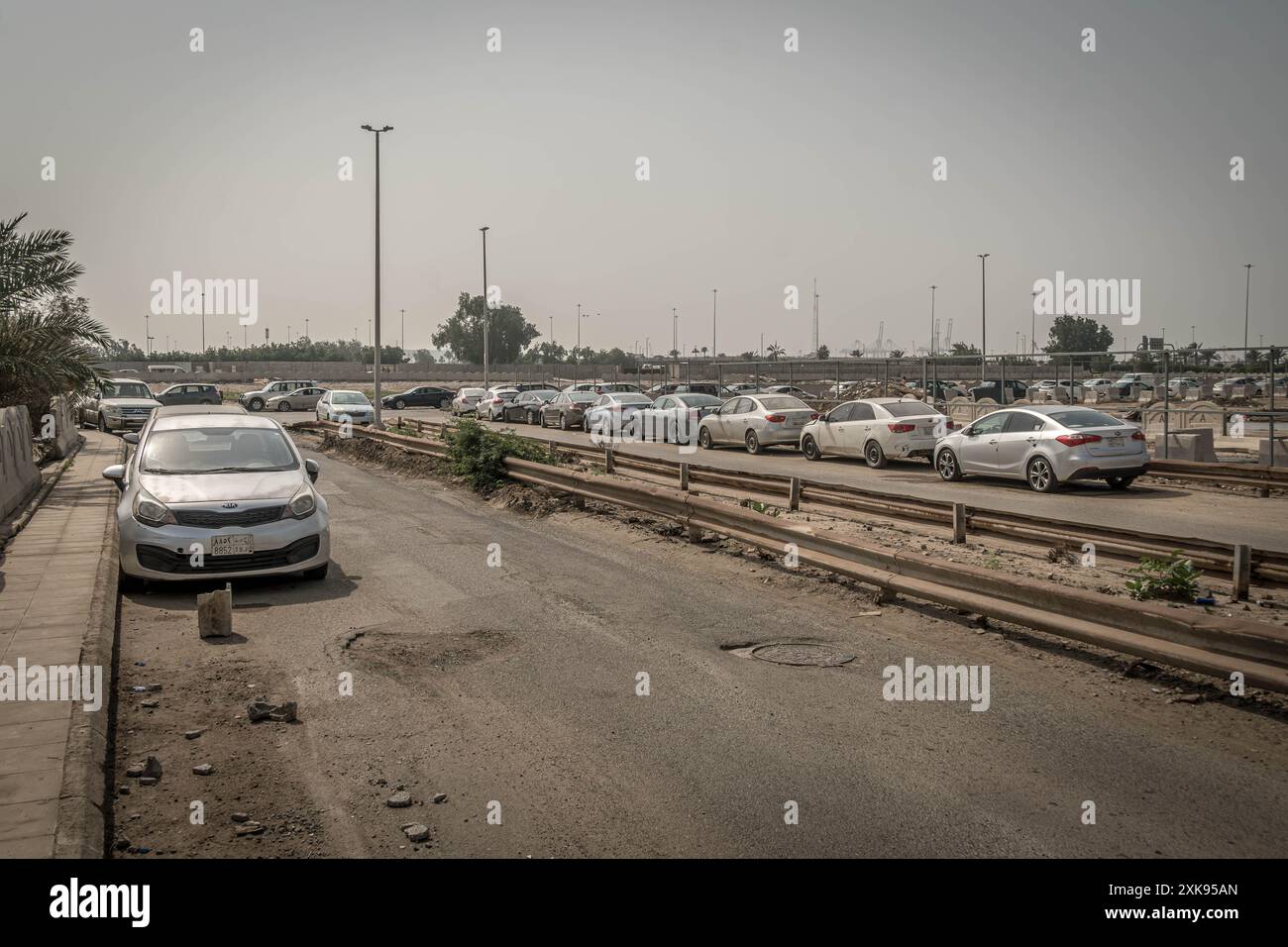 The cars parked on the bad condition road in Jeddah, Saudi Arabia, in ...