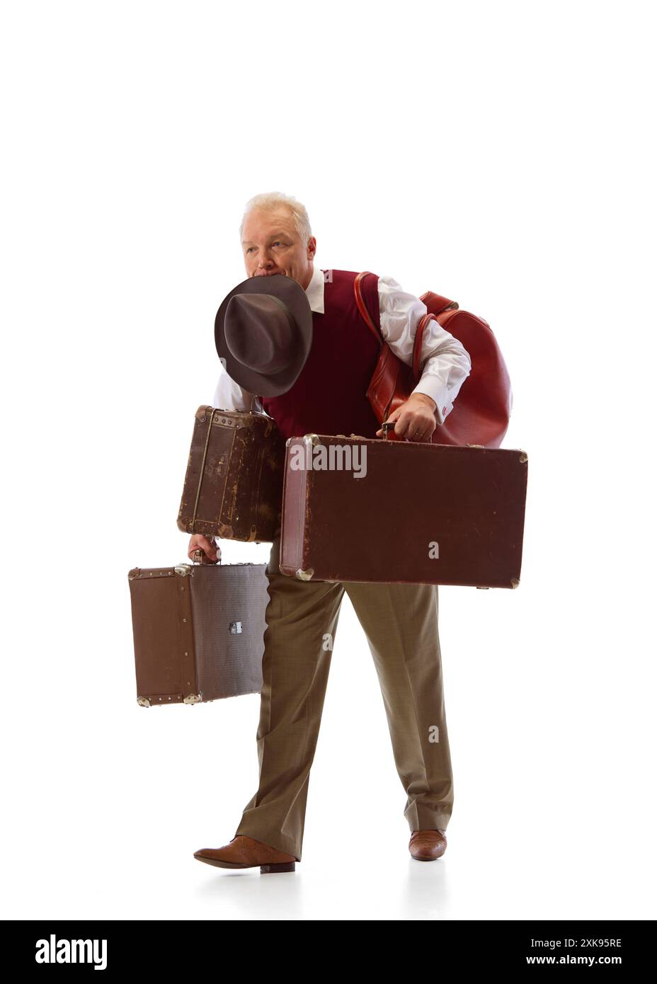 Elderly man, with hat held in his mouth, dressed vintage style outfit ...