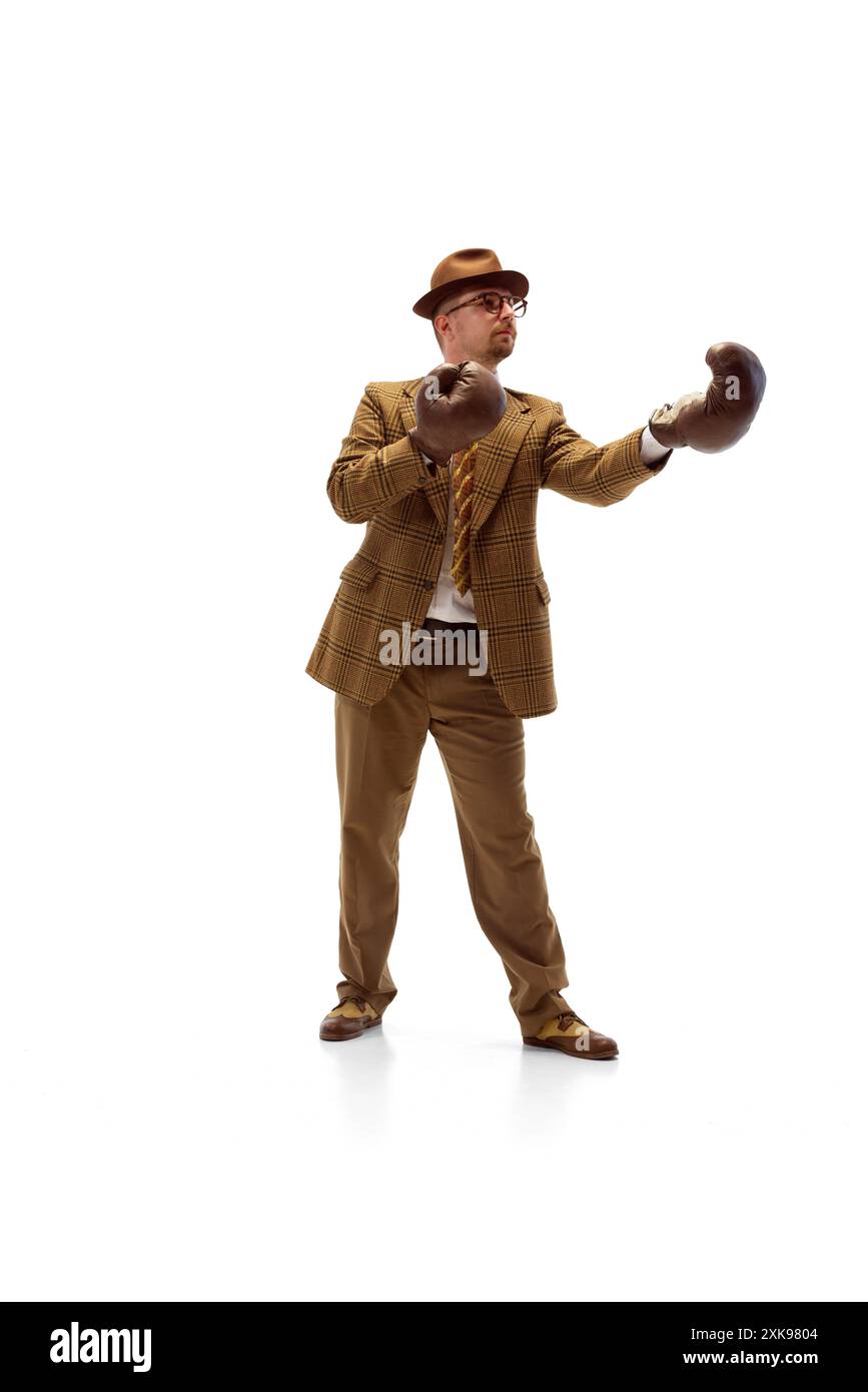 Man in formal outfit stands in boxing stance wearing boxing gloves ...
