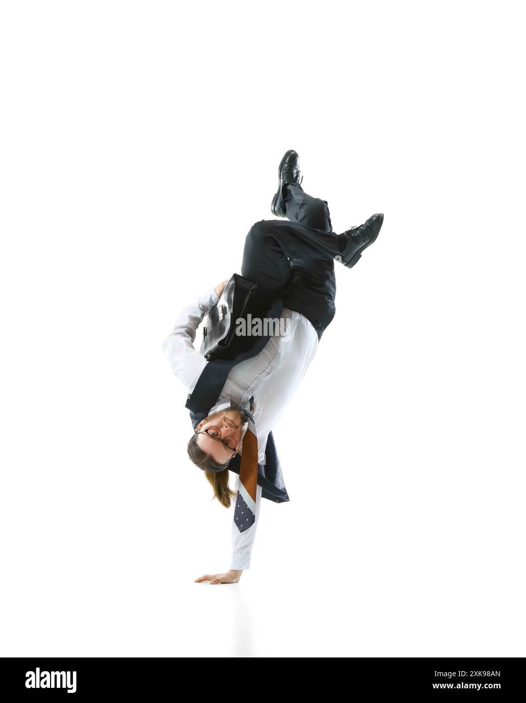 Professional, dressed in formal attire performs dynamic handstand ...