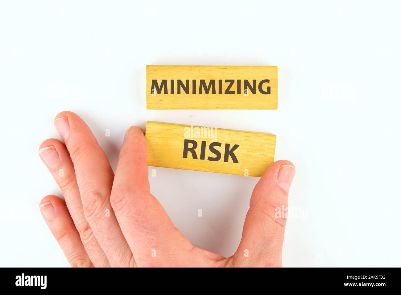 MINIMIZING RISK word written on wooden blocks laid out by hand on a ...