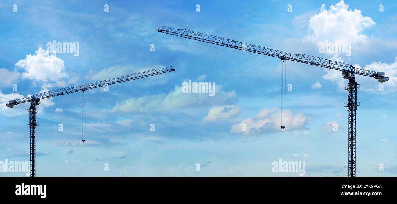 Construction crane working on building site against blue background ...