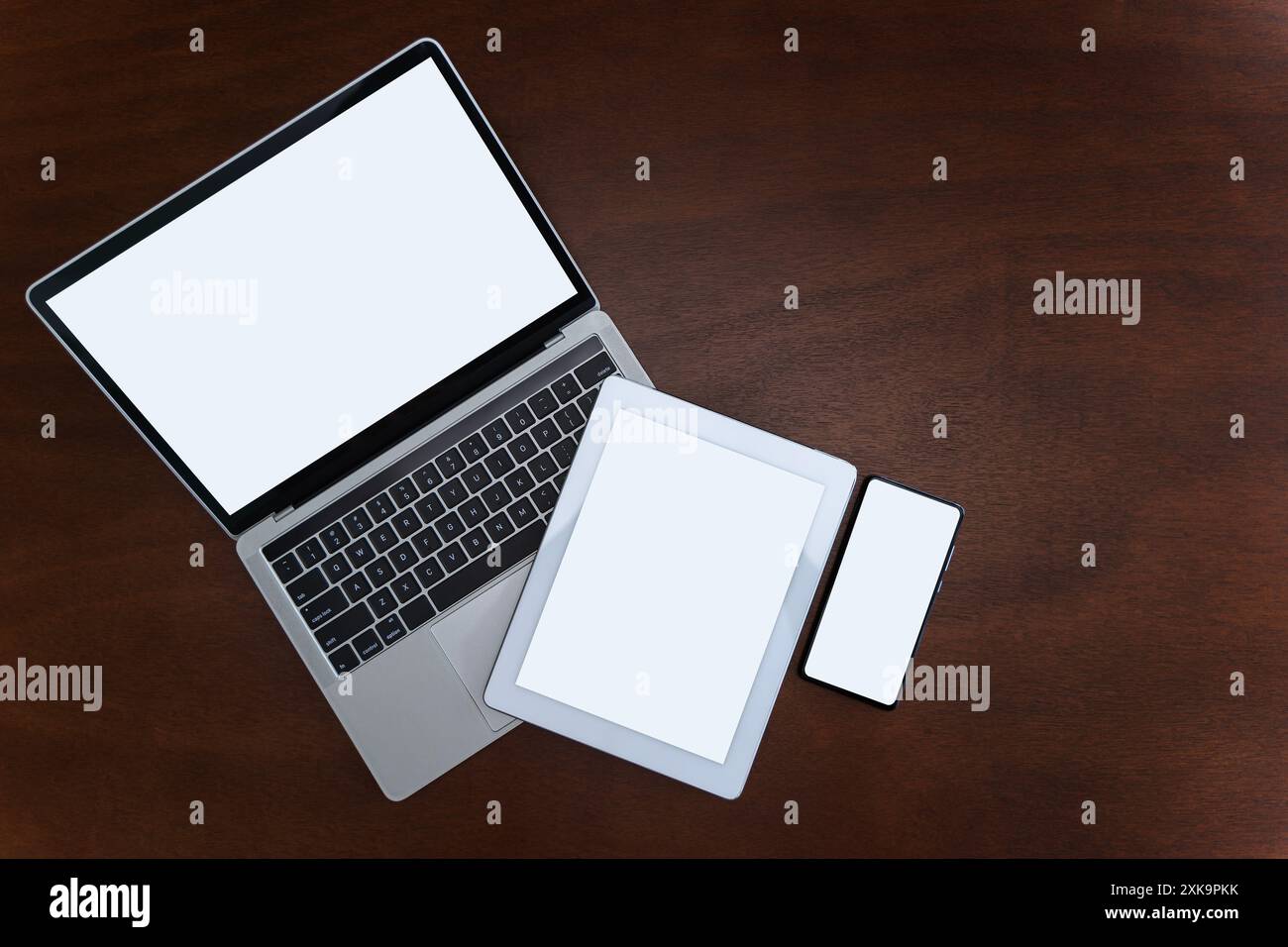 Laptops, tablets and smartphones with blank screens on table, devices ...