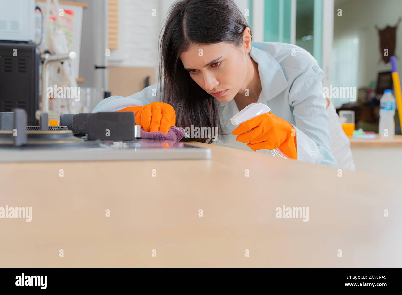 Beautiful young cleaning service woman worker clean kitchen table at ...