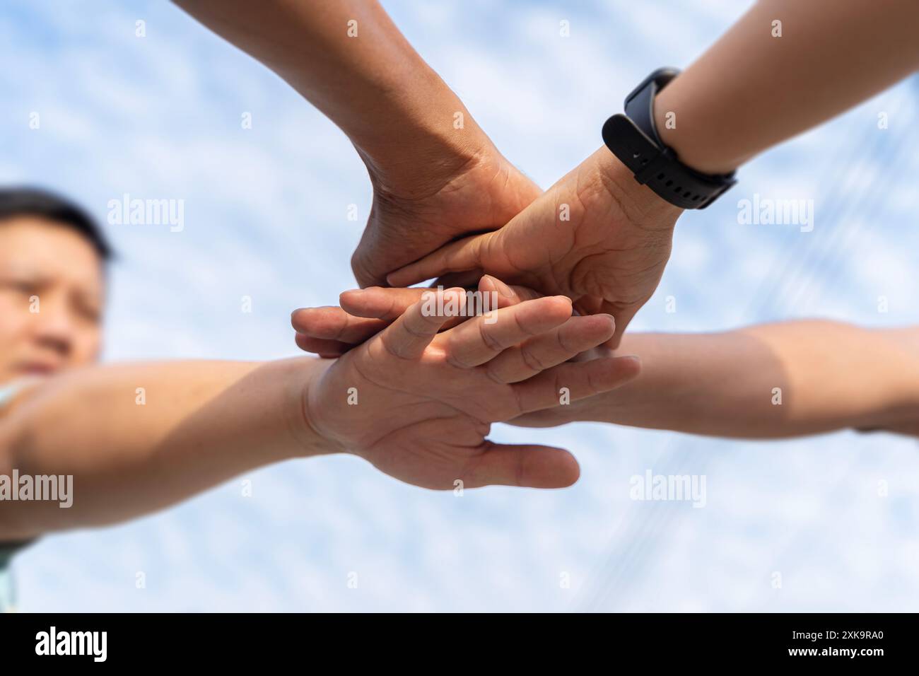 Close up low angle of business people putting their hands together. Stack of hands. Unity and ...