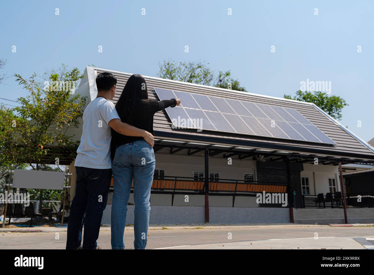 Family uses renewable energy system with solar panel. Rear View Of A ...