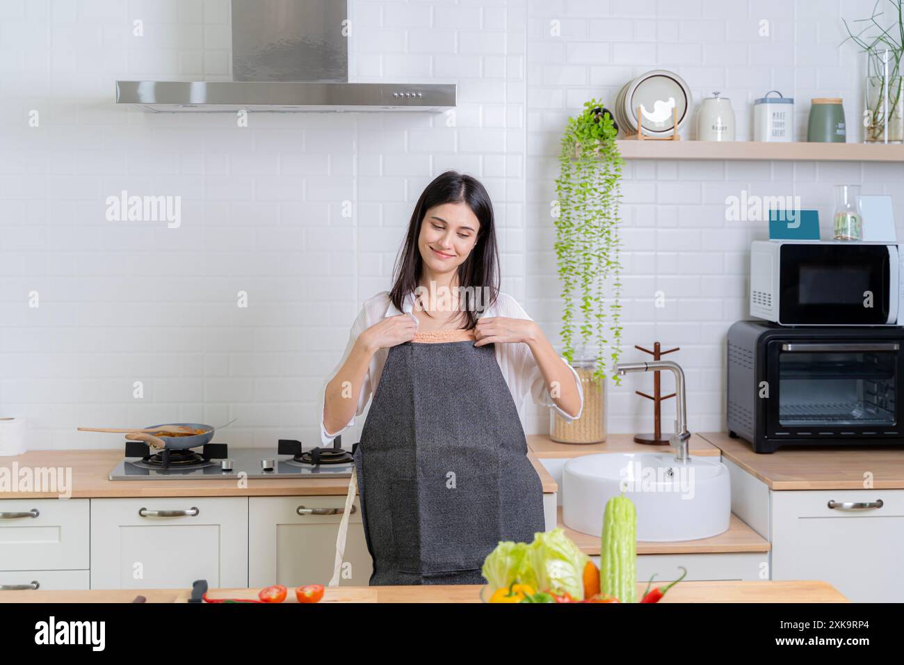 Woman preparing salad in the kitchen. Pretty housewife introduce about ...