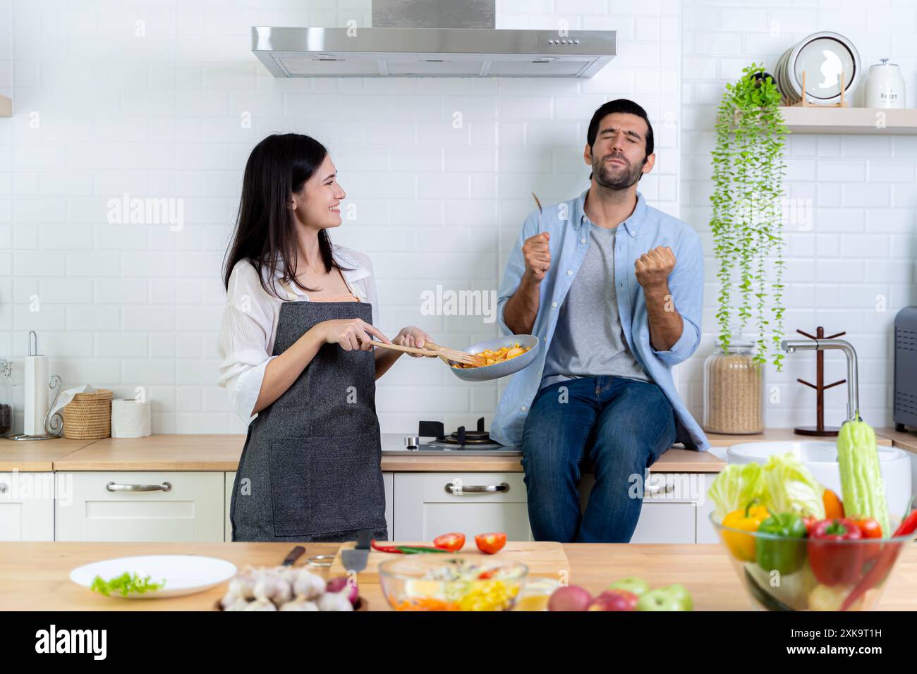 Romantic Couple At Kitchen. Man tasting food with good taste. Beautiful ...
