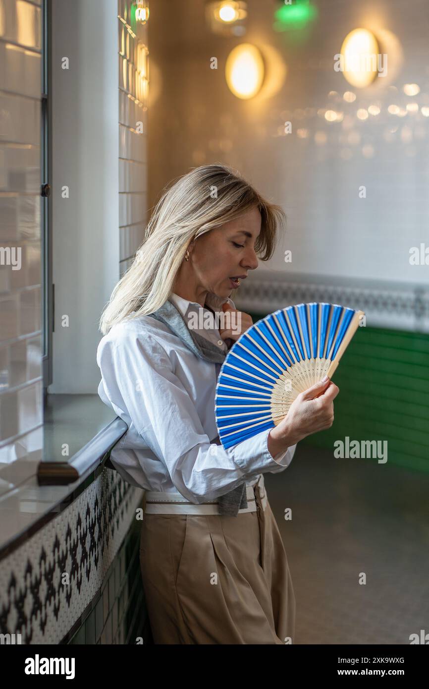 Woman indoors cooling herself fan hi-res stock photography and images ...