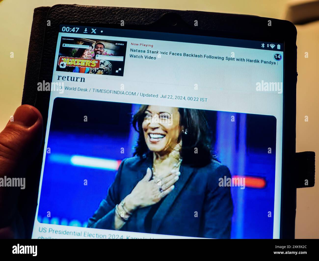 In this photo illustration, a hand holds a tablet with a publication in ...