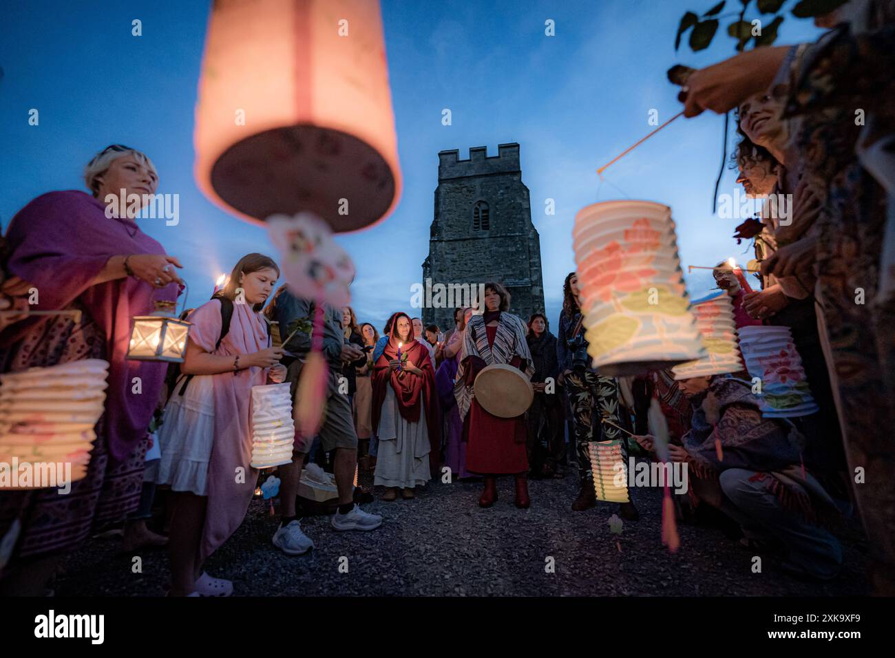 People sing and hold lanterns on the pilgrimage of light, during the Sacred Magdalene Festival ...