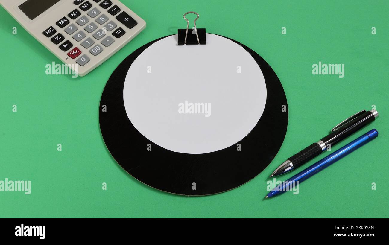 Round white paper with green background on the desk Stock Photo - Alamy
