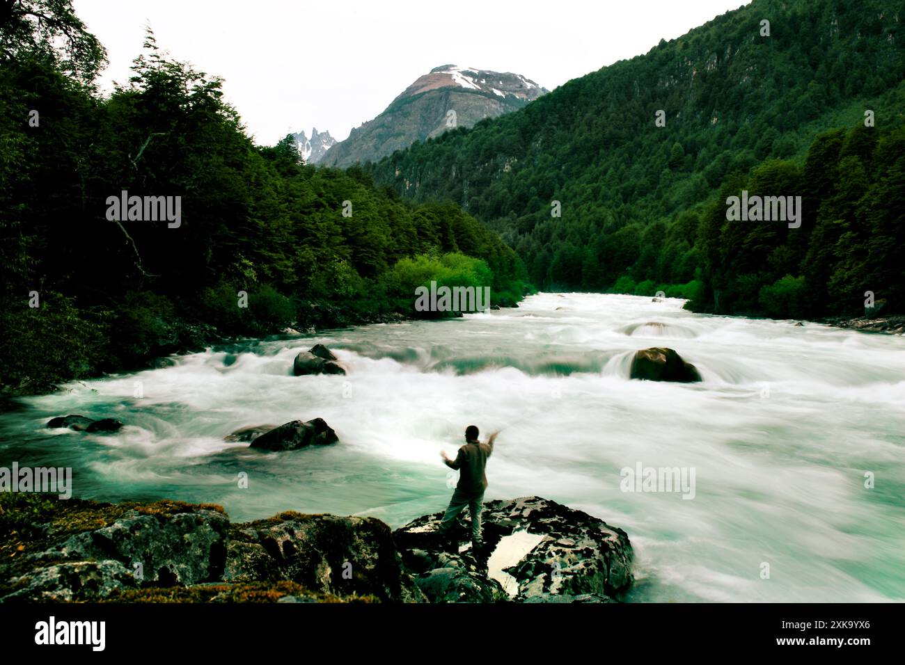 Fly fishing, seen in a long exposure, blurring rapids in the Futaleufu ...