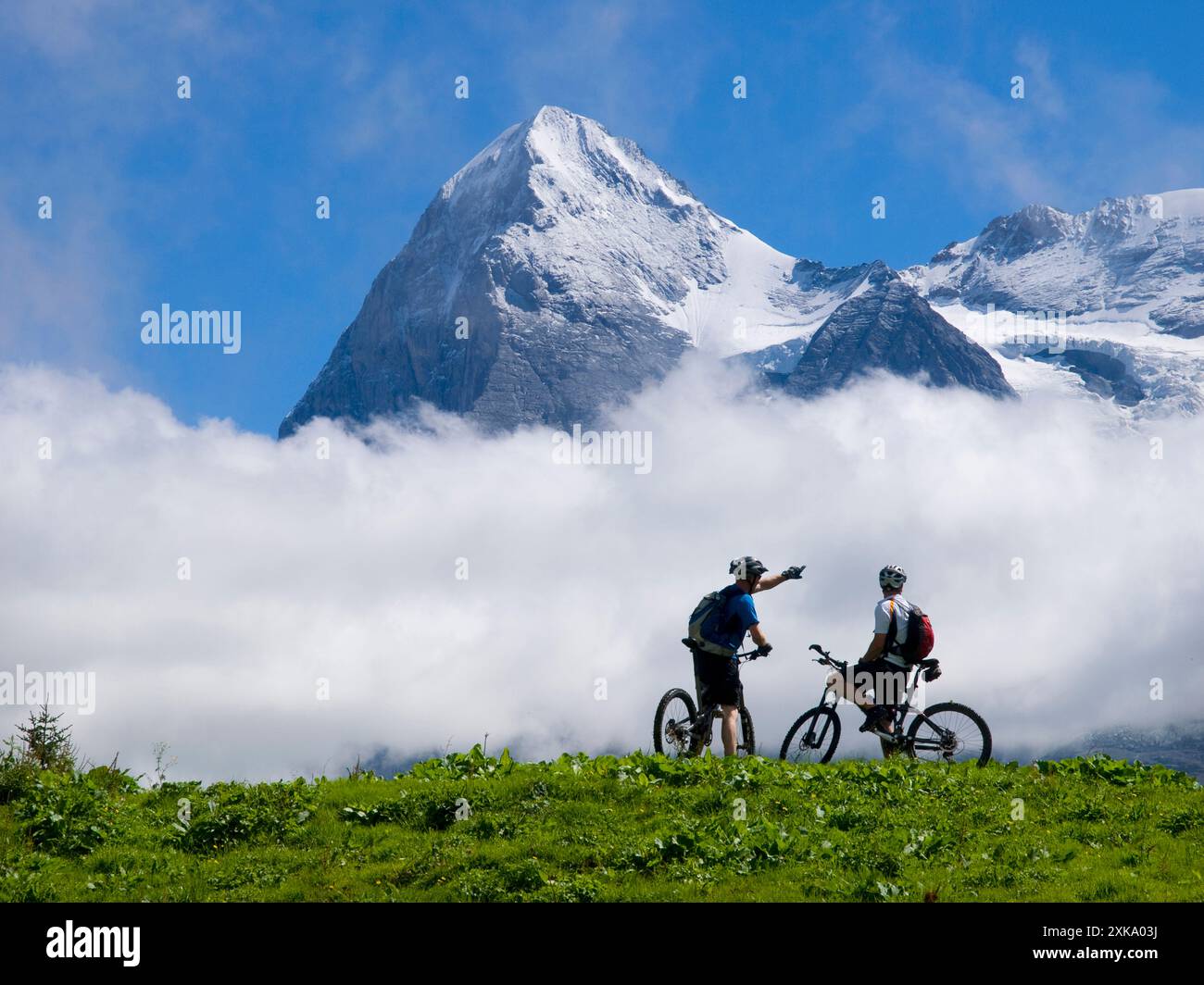 Two mountain bikers are resting near the village of Murren, during a long bike ride in the ...