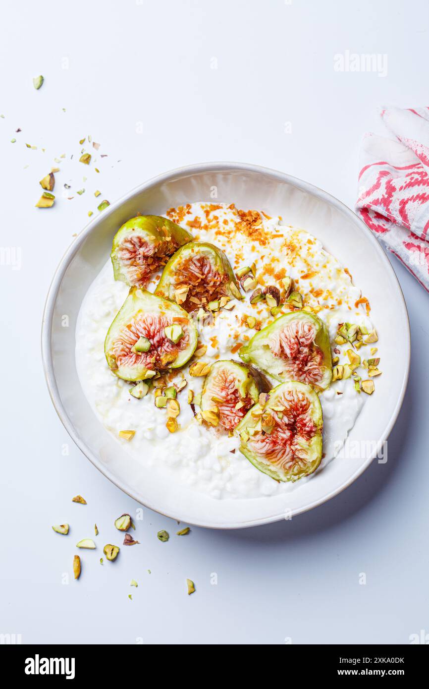 Breakfast cottage cheese with figs and maple syrup, white background ...